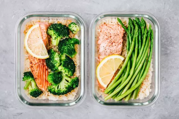 Bliuw sûn mei in budzjet: Lunchboxkonteners foar itenfoarbereiding mei bakte salmfisk, rys, griene brokkoli en asperzjes