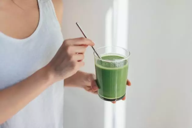 Beljakovinski praški za ženske: Mlada ženska pije zeleni sok za čistilno dieto