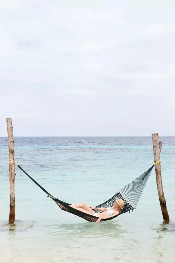 ຮູບພາບຂອງແມ່ຍິງຢູ່ໃນ hammock ຫາດຊາຍ