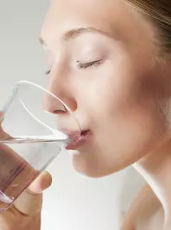 Mujer bebe un vaso de agua - bocadillos inteligentes por la mañana - salud