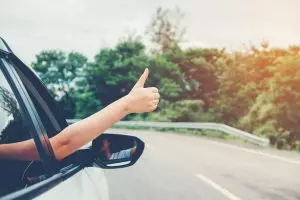 vrouw zwaait hand uit raam